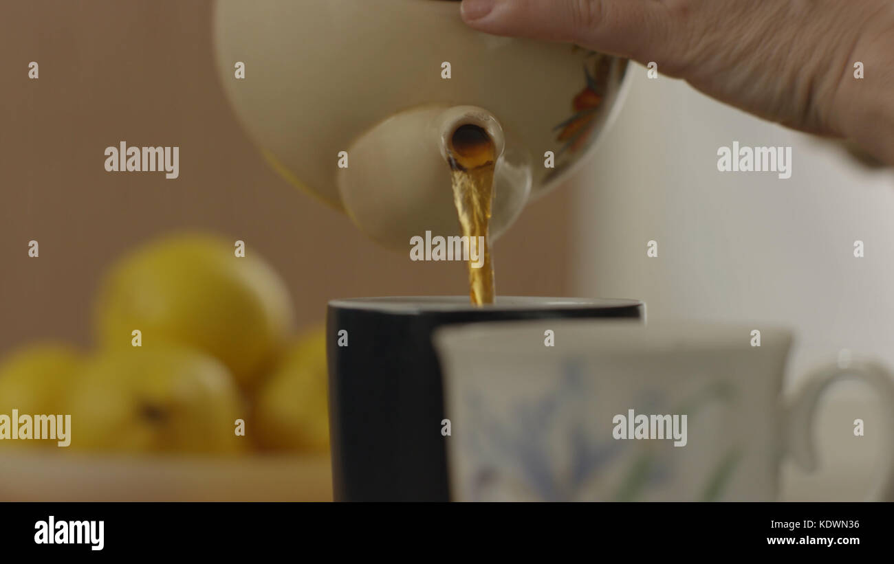 Woman's hand pour tea from teapot into the glass Stock Photo - Alamy