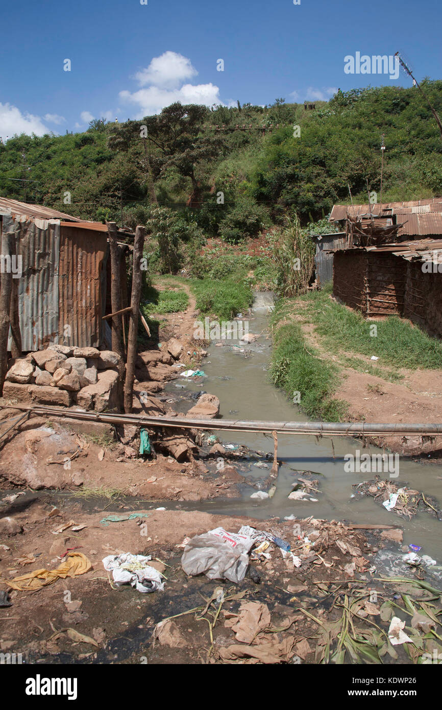 Rubbish around polluted river running through two shacks in the Kibera ...