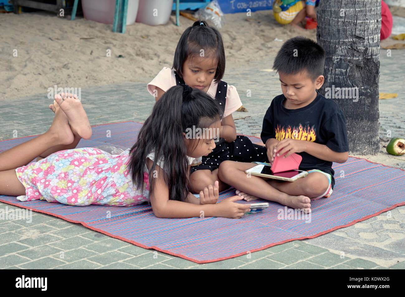 Children playing outdoors with smartphones and iPad tablet computers ...