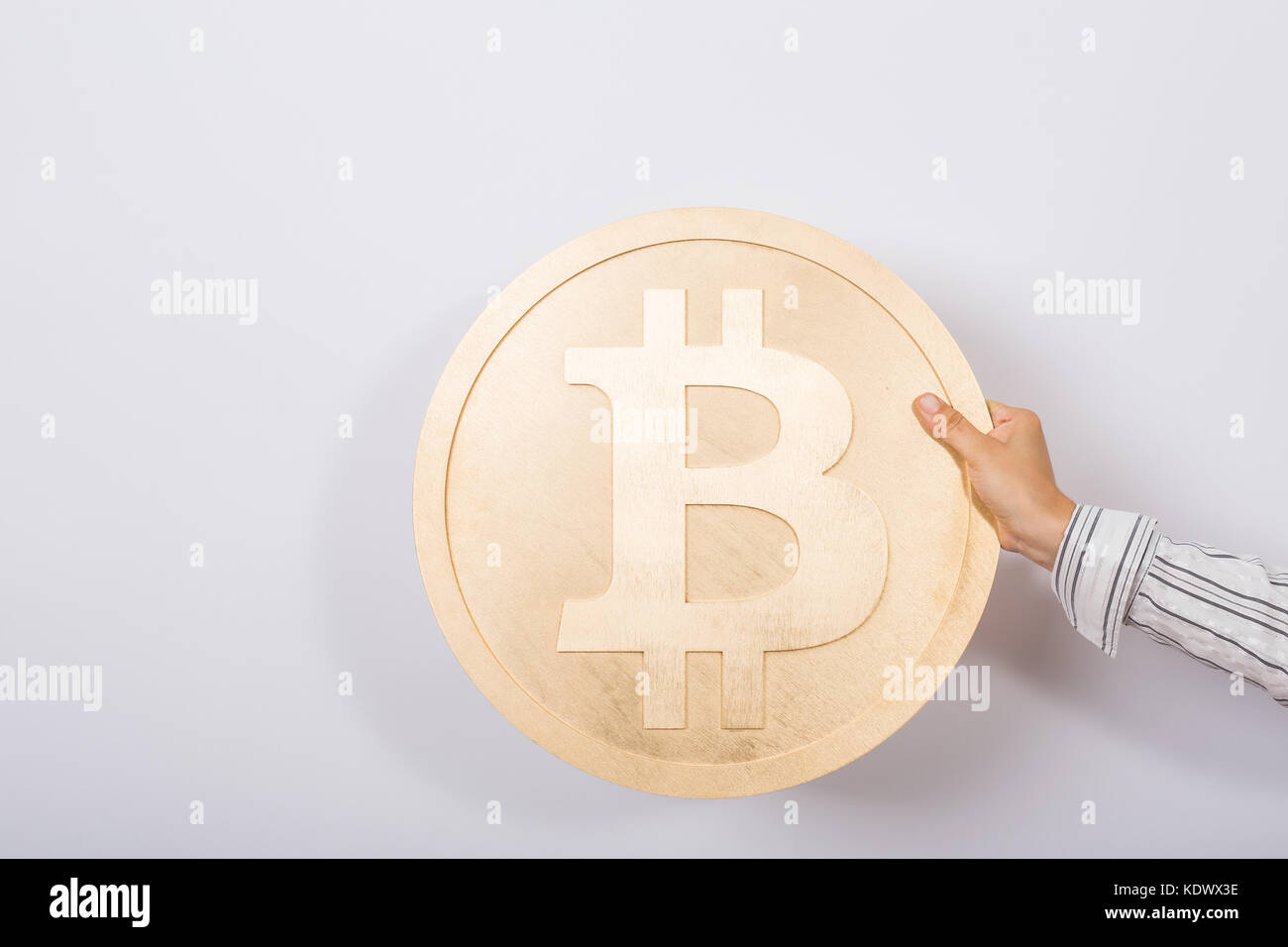 Big gold bitcoin in hand on white background Stock Photo - Alamy