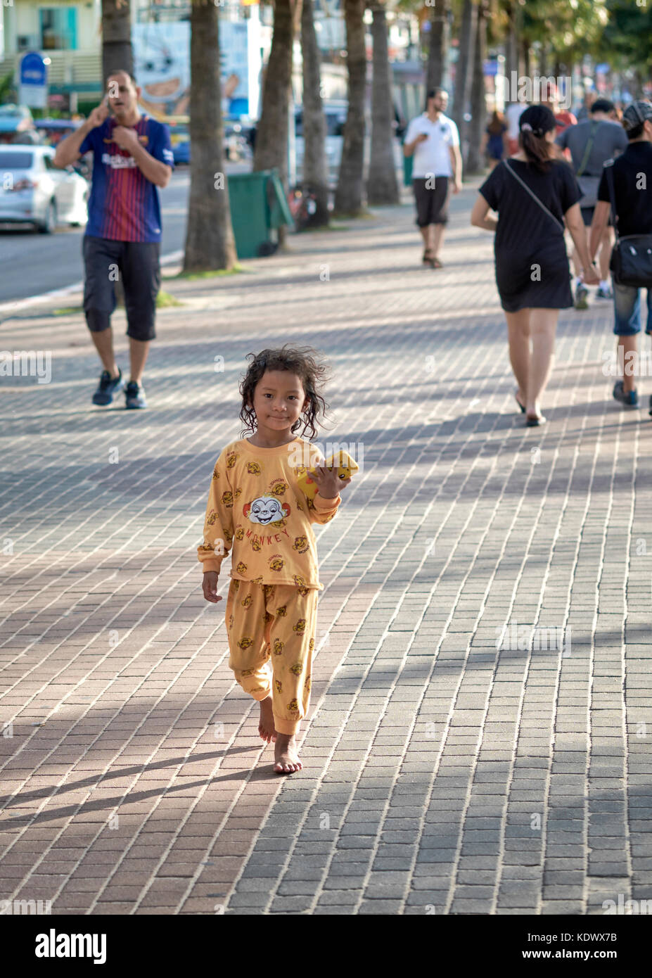 Child alone, playing outside, barefoot, bare feet, street, pavement ...