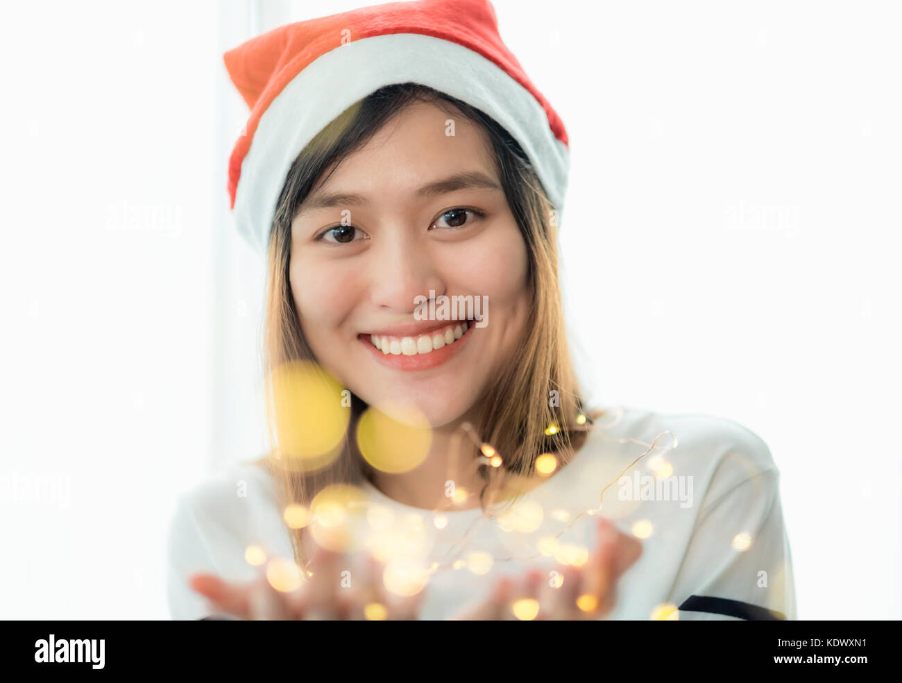 Smiling Asia Woman Wear Santa Hat Holding Party String Lights With
