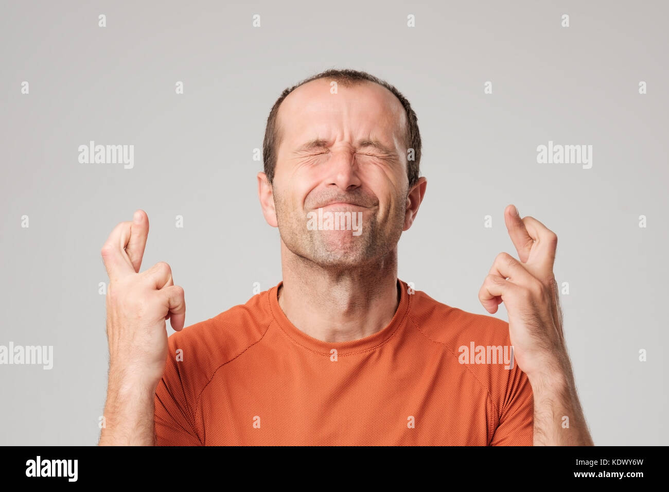 Mature hispanic man making a wish sign with crossing fingers isolated ...