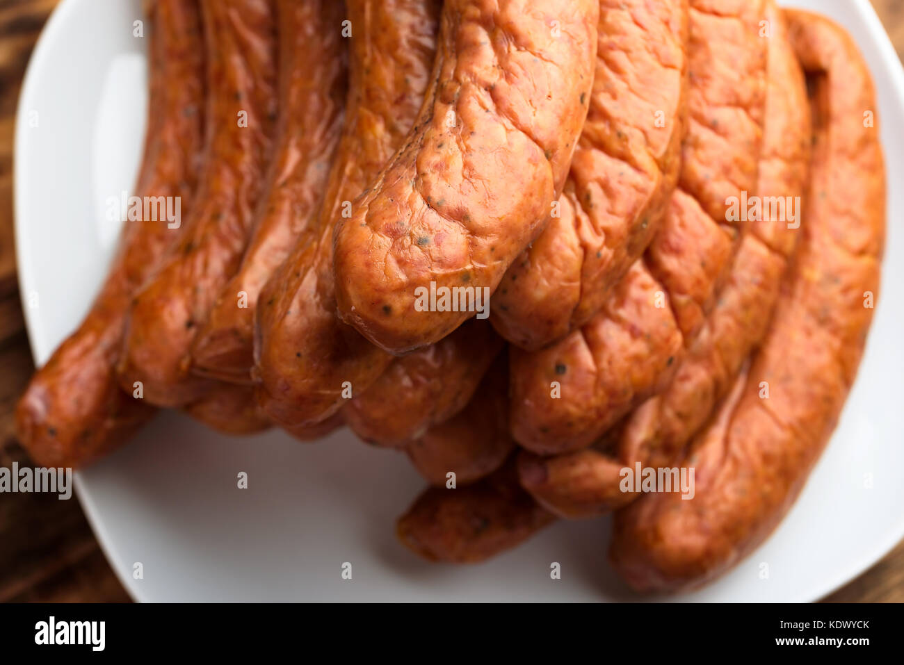 Stack of deliciously cold smoked handmade sausages with visible black ...