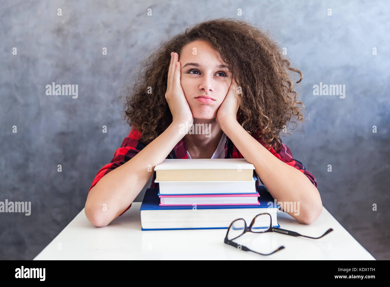 Portrait of tired curly hair teen girl rest from learning on books ...