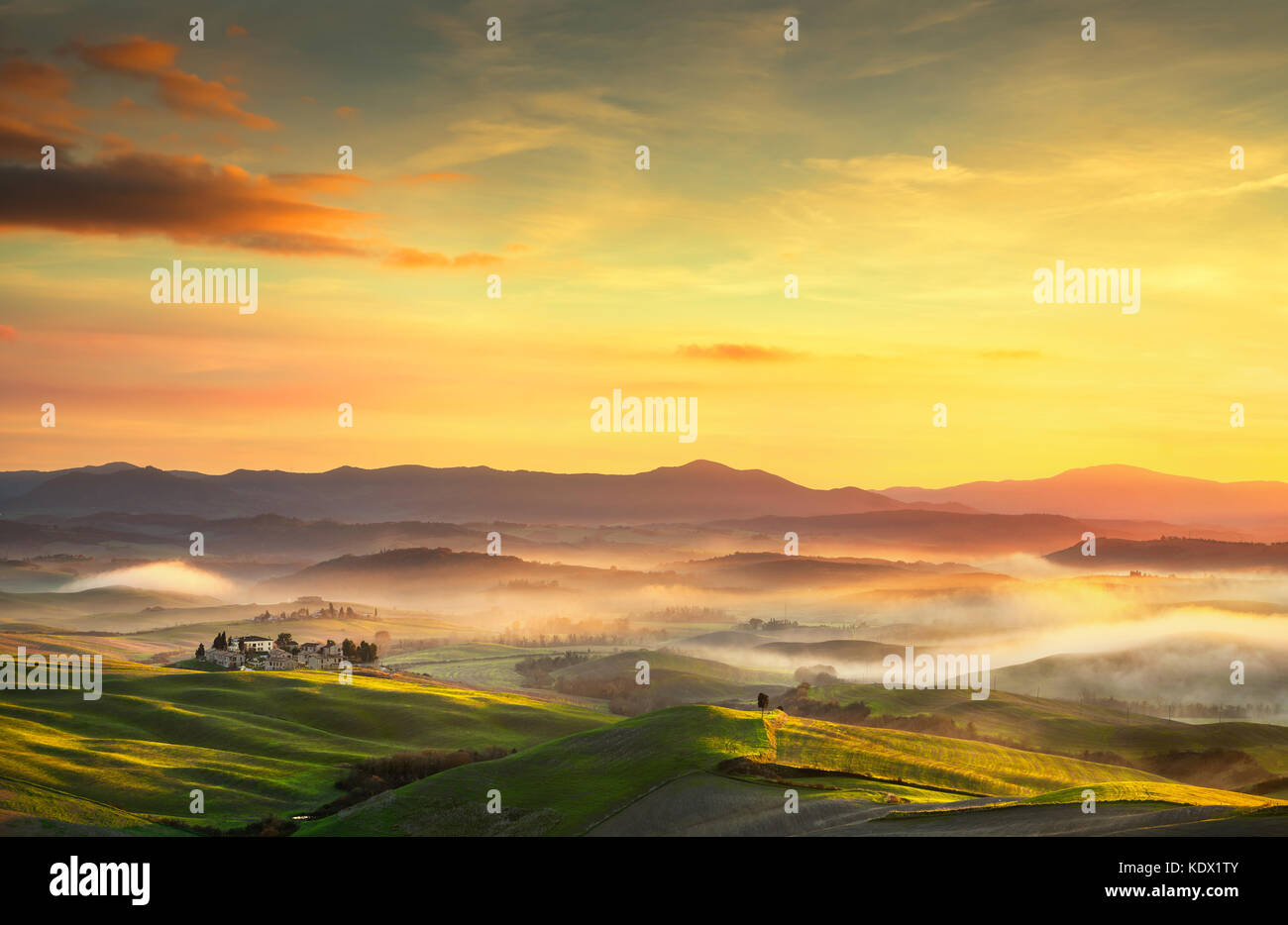 Volterra foggy panorama, rolling hills and green fields on sunset ...