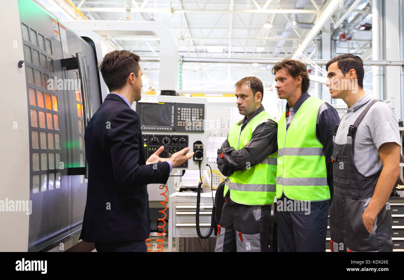 Manager and workers at plant near CNC machines Stock Photo - Alamy