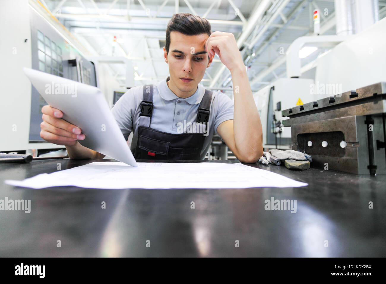 Man working with documents at plant near CNC machines Stock Photo - Alamy