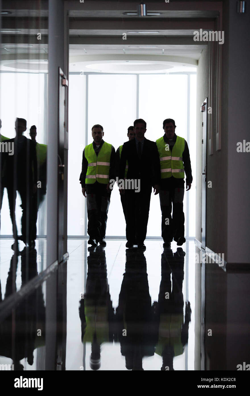 Team of workers and manager walking at the corridor of factory Stock ...