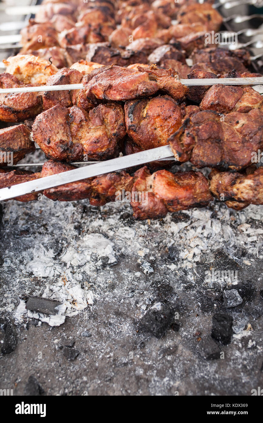 Grilled kebab cooking on metal skewer. Roasted meat cooked at barbecue ...