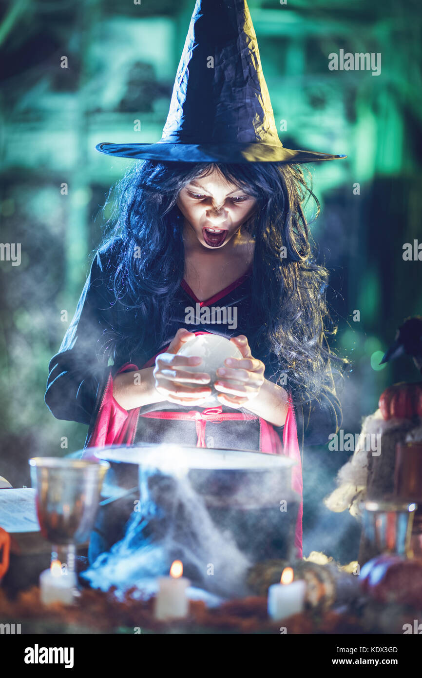 Portrait of young angry witch with awfully face in creepy surrounding ...