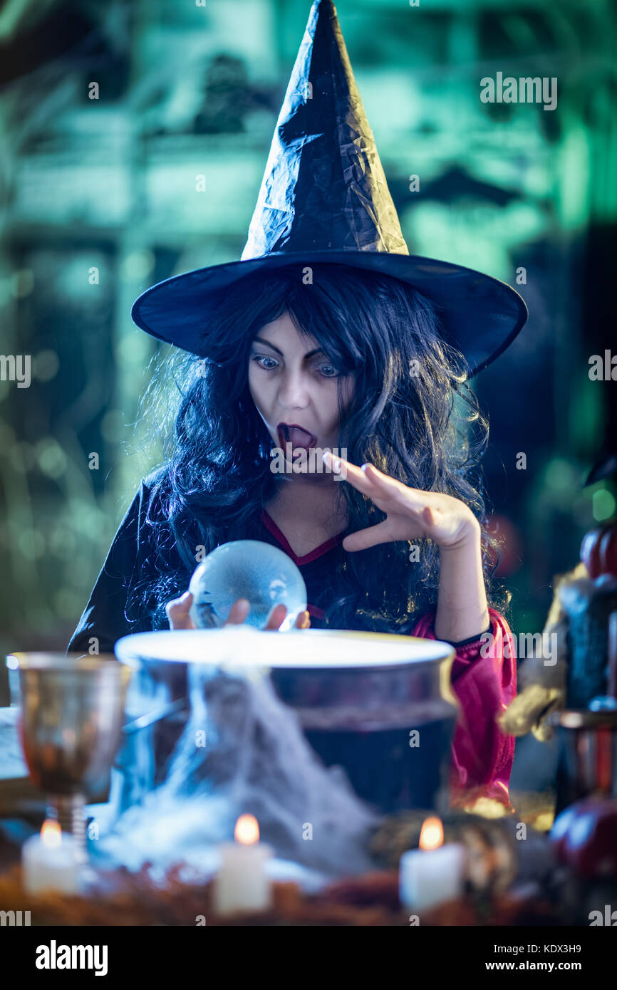 Portrait of young witch with awfully face in creepy surrounding ...