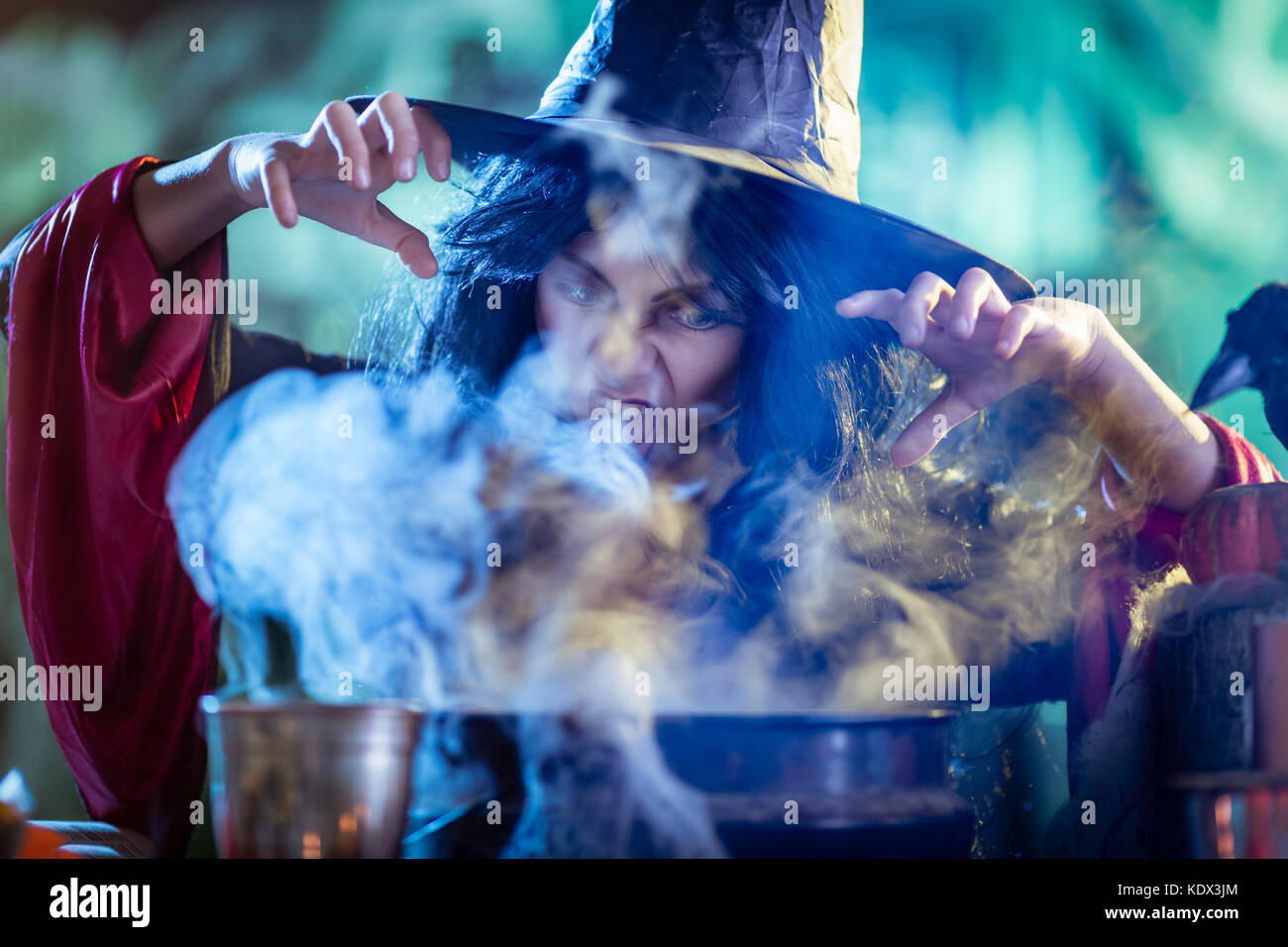 Close-up of young witch with awfully face in creepy surroundings full ...