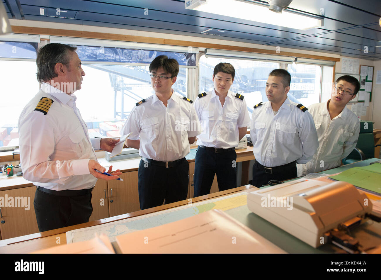 Captain and officers discuss navigation plans on board a merchant ship ...