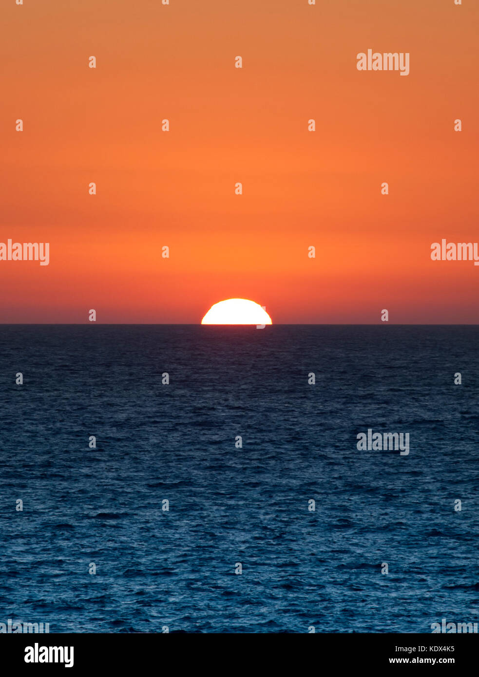 A beautiful golden sunset over calm ocean waters Stock Photo - Alamy