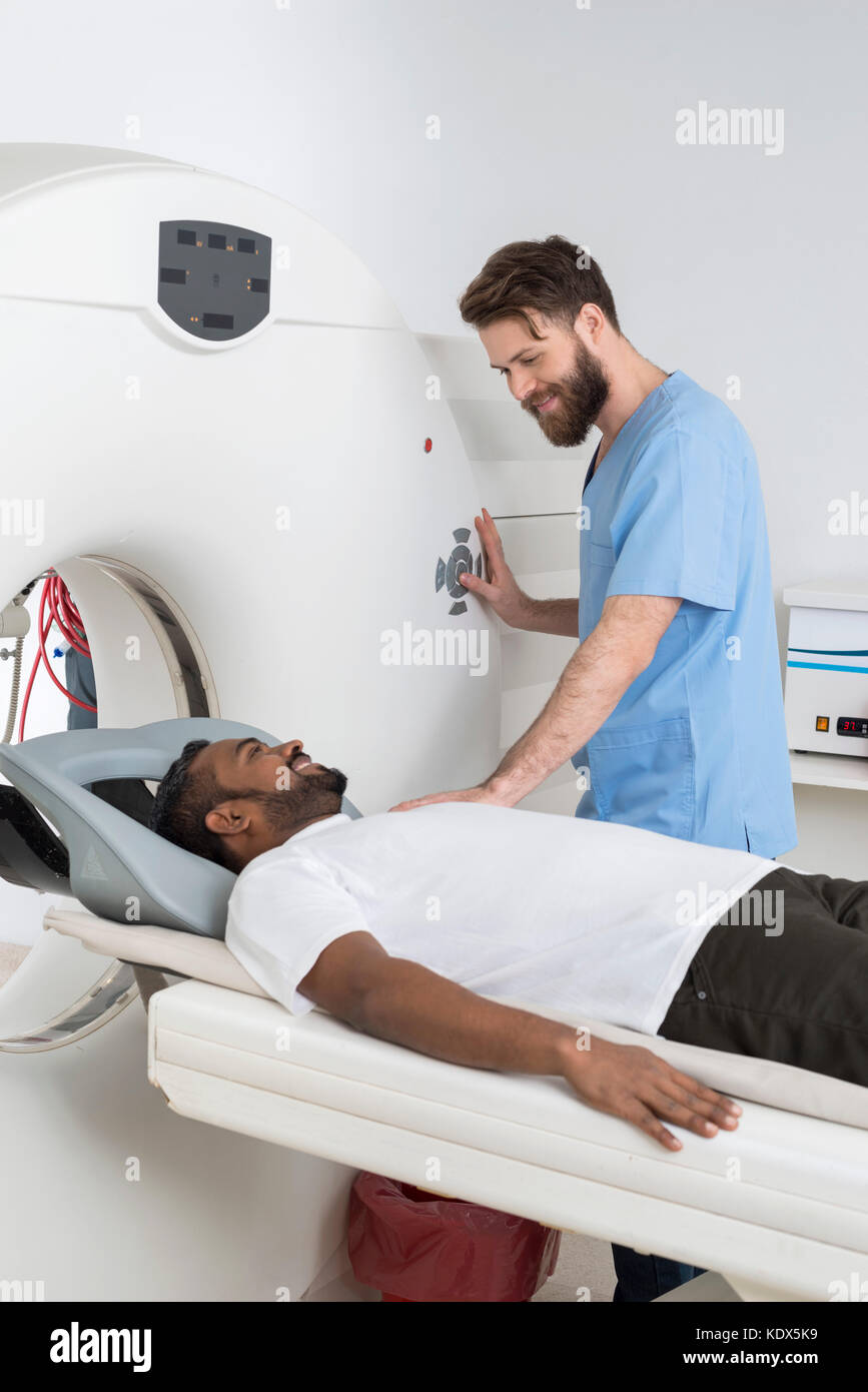 Young male professional about to start CT scan on patient in ...