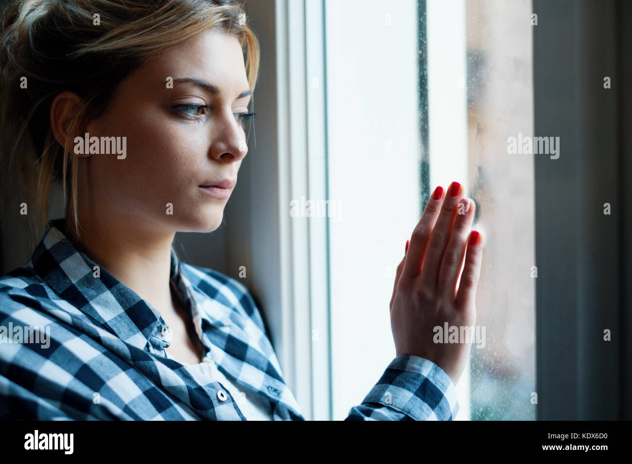 Girl looking out window sad rain hi-res stock photography and images ...