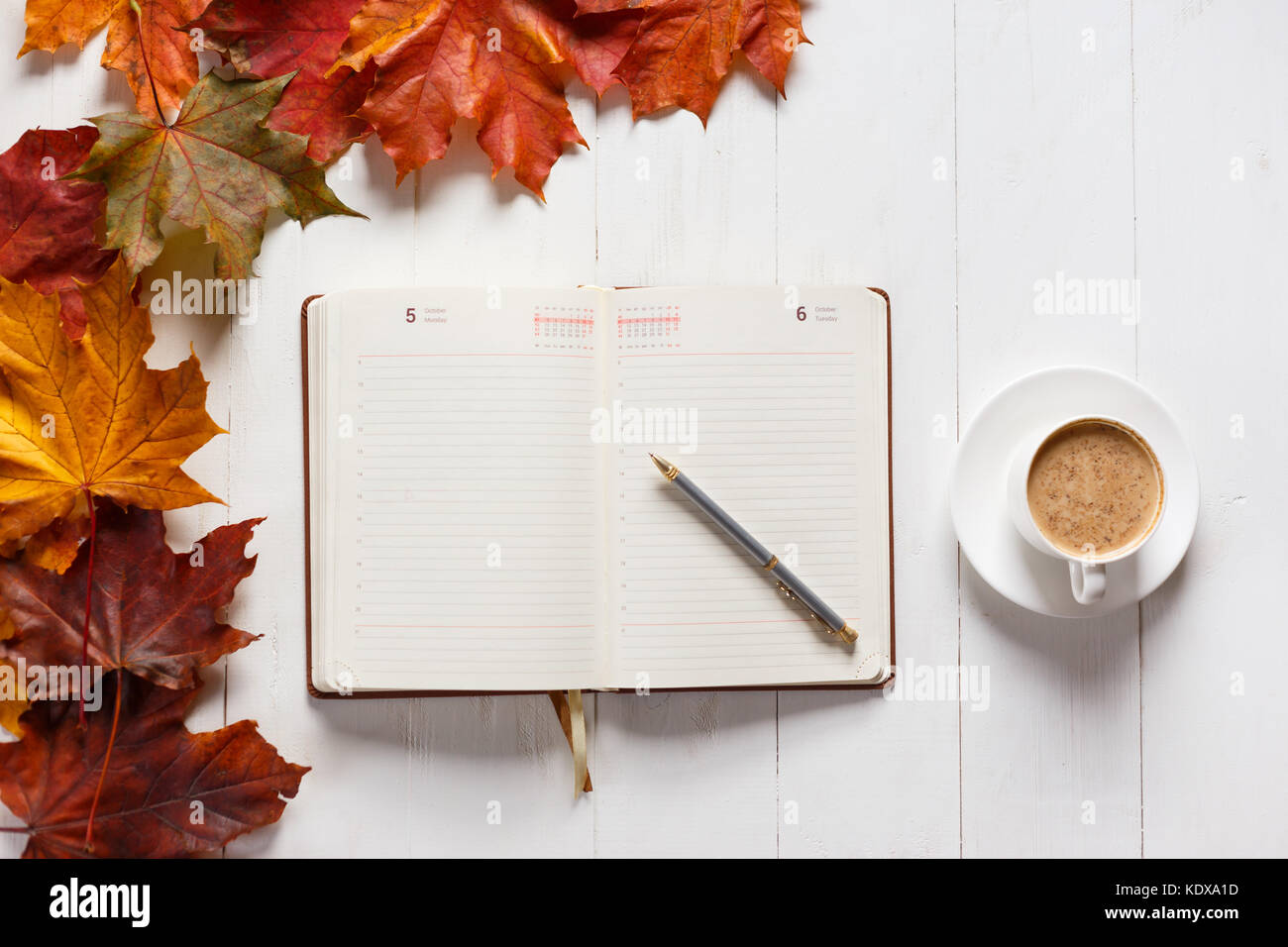 The concept of autumn mood. Morning coffee, diary and colored maple ...