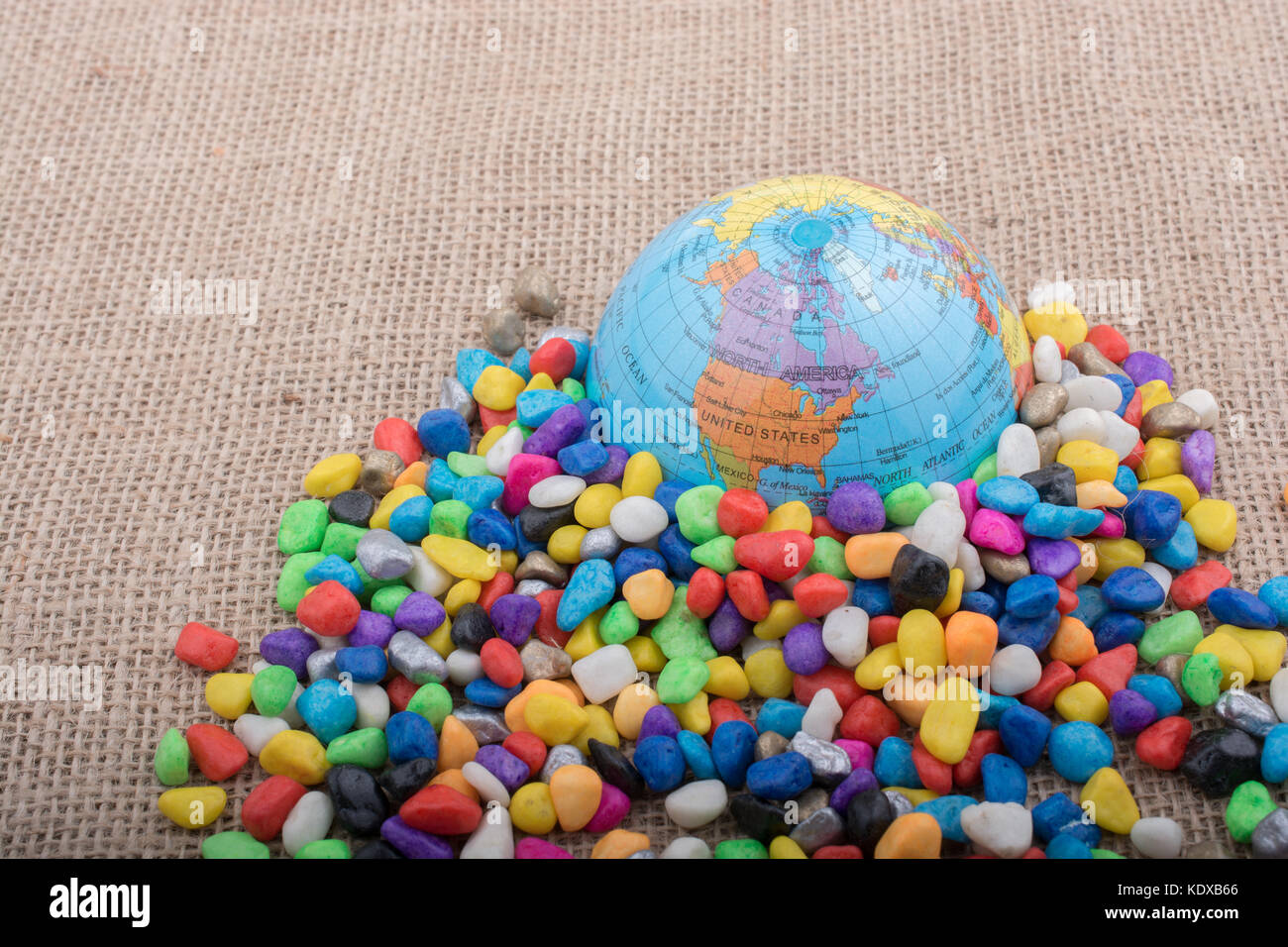 Model globe placed amid colorful pebbles Stock Photo - Alamy