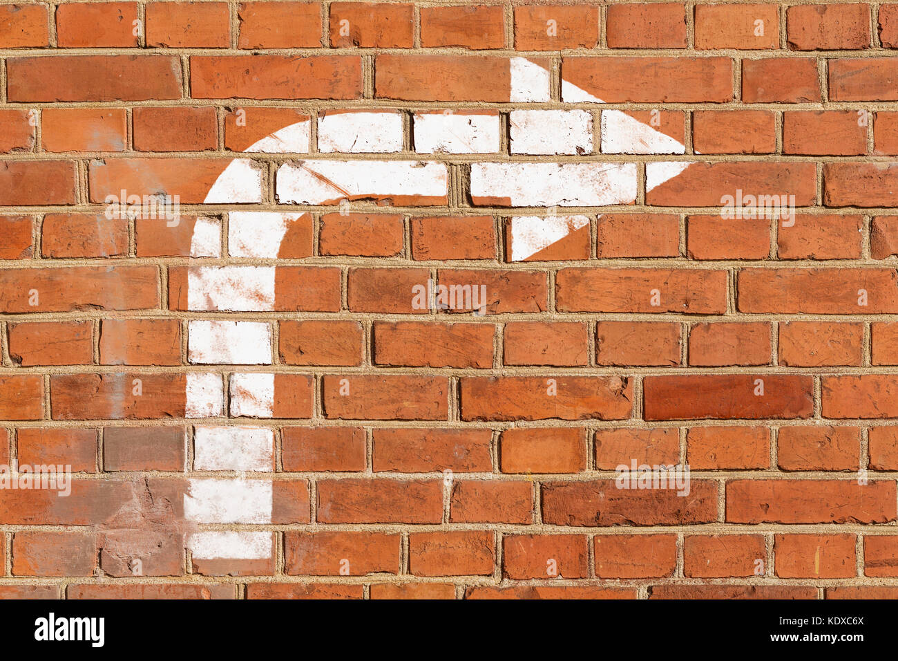 Brick wall with a driving direction sign Stock Photo - Alamy