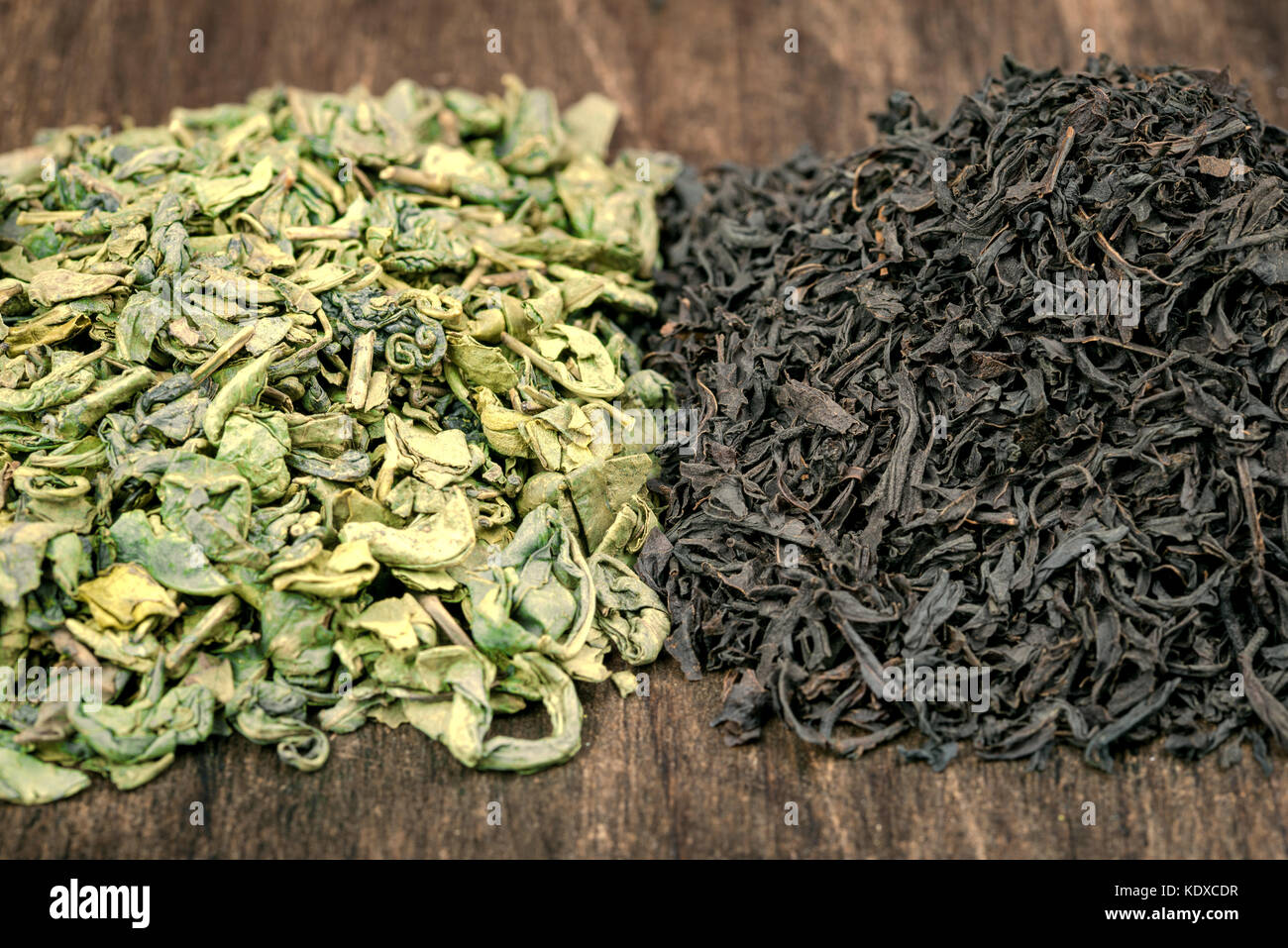 Green or black tea leaves on wooden plate or background Stock Photo - Alamy
