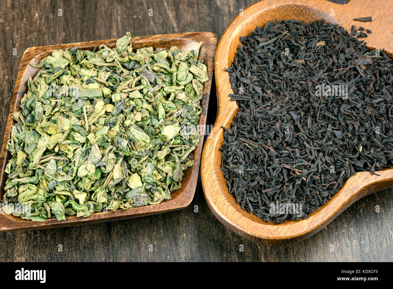 Green or black tea leaves on wooden plate or background Stock Photo - Alamy