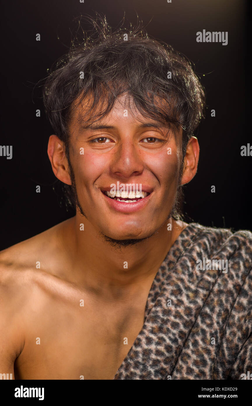 Close up of funny prehistoric man smiling to the camera in a black ...