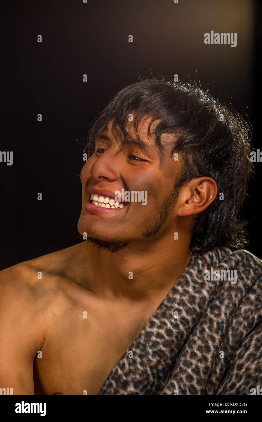 Close up of funny prehistoric man smiling to the camera in a black ...