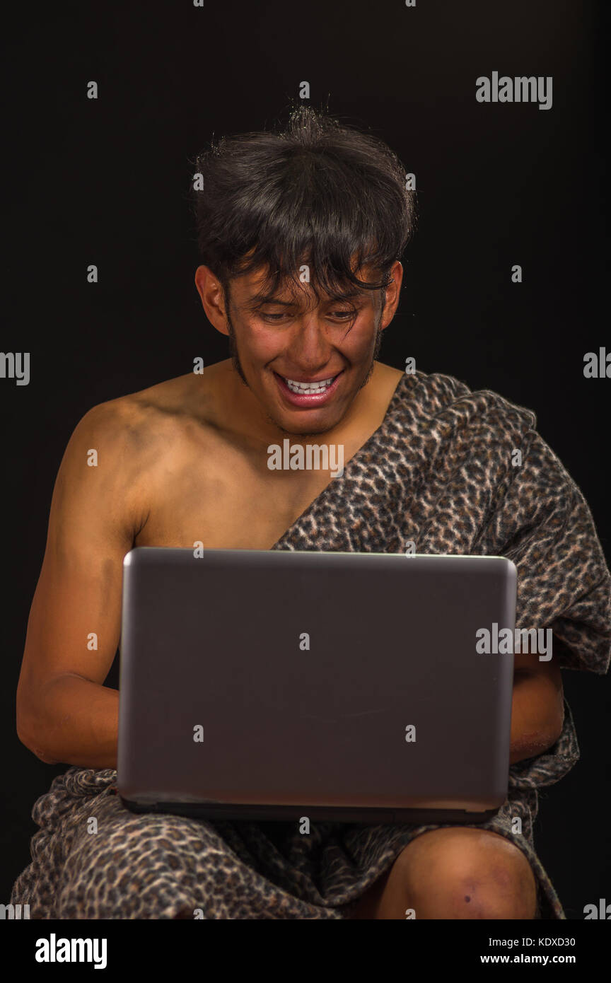 Close up of prehistoric man working in his computer, in a black ...