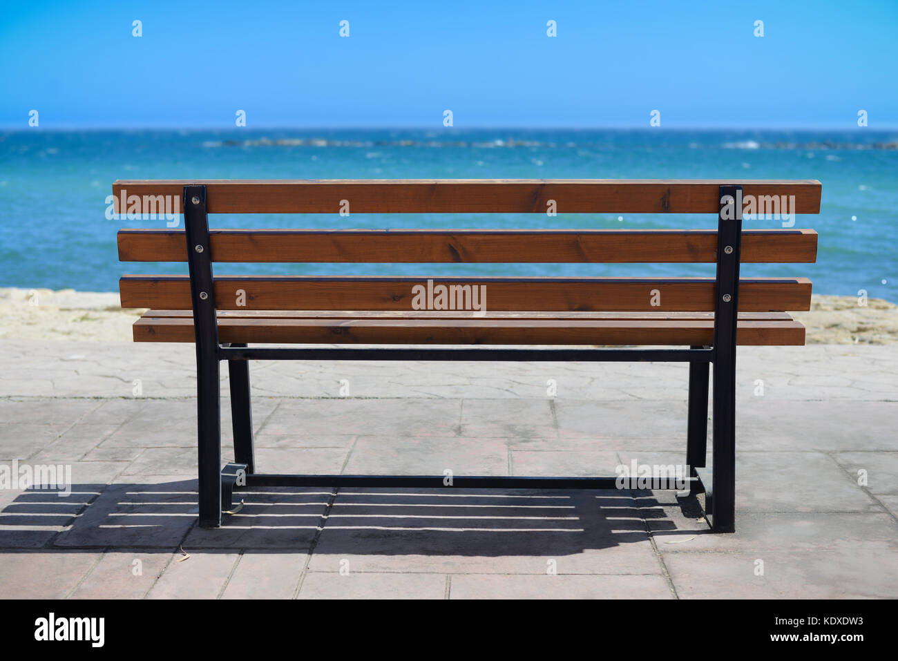 Empty wooden rest bench at sea shore by sunny summer day Stock Photo ...
