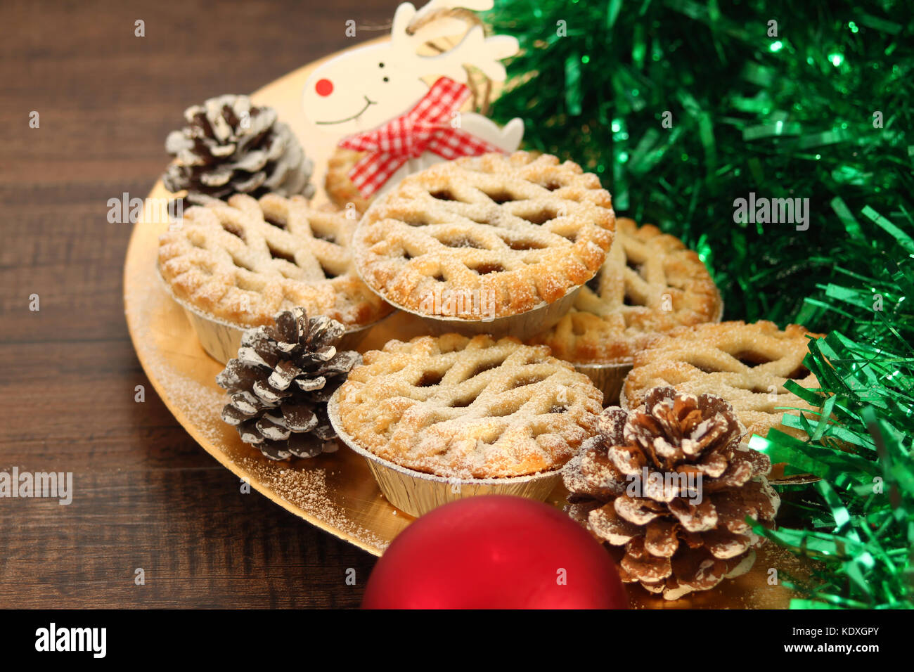 Christmas mince pies on a gold plate with white reindeer on a wood ...