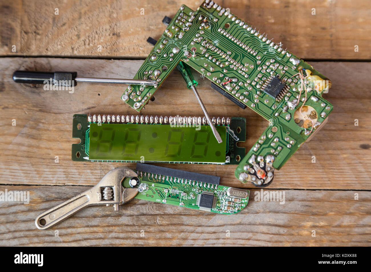 integrated computer circuit damaged with tools on a wooden table Stock ...