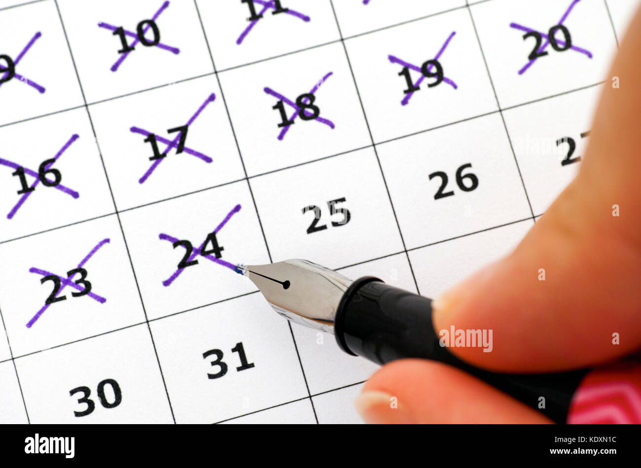 Fountain pen in woman hand marking days in calendar. Close-up Stock ...