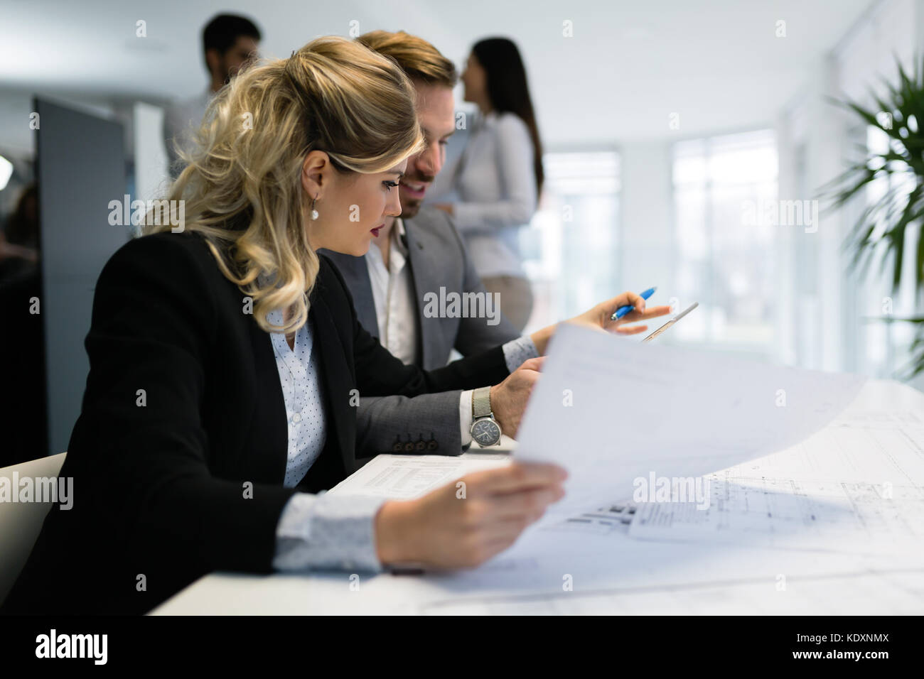 Young attractive architects working on project in office Stock Photo ...