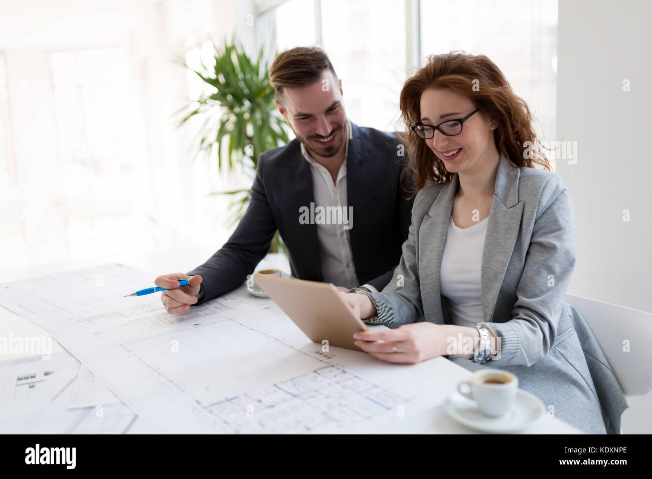 Young attractive architects working on project in office Stock Photo ...