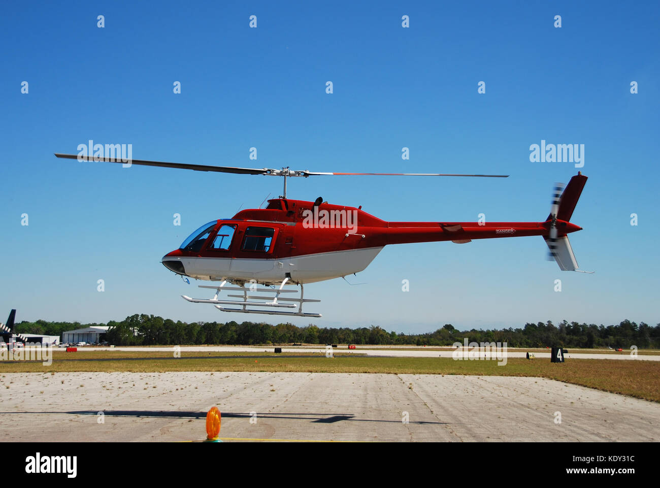 Side view of red helicopter above ground Stock Photo - Alamy