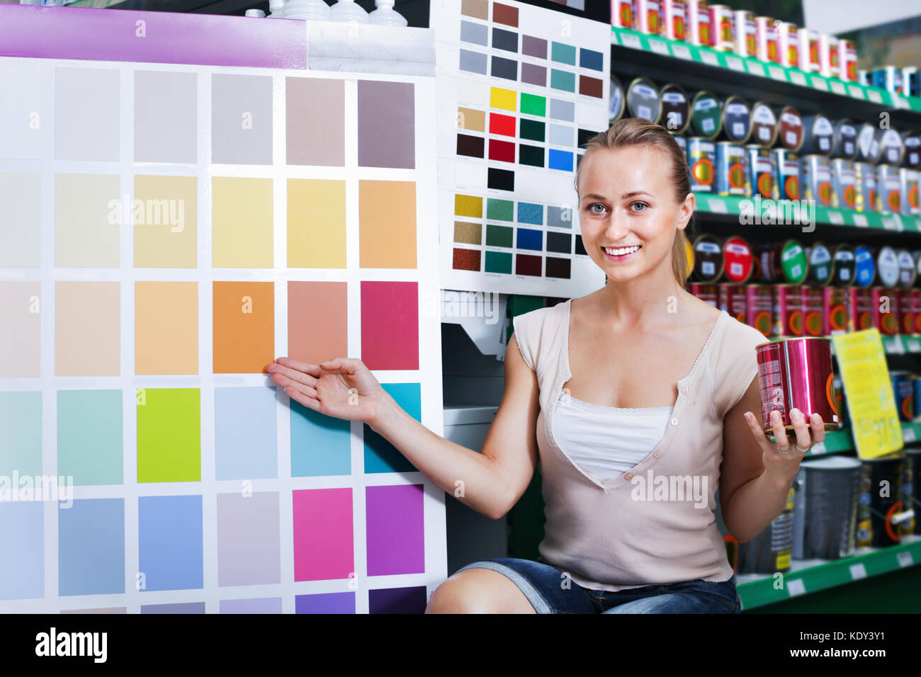 Smiling young woman choosing color for painting using palette scheme in ...