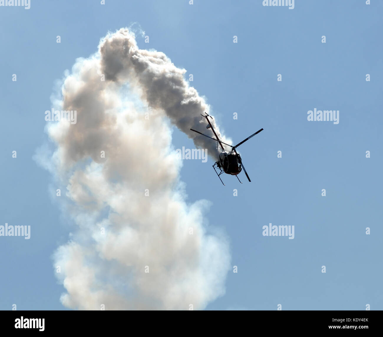 Light helicopter with thick smoke trail Stock Photo - Alamy