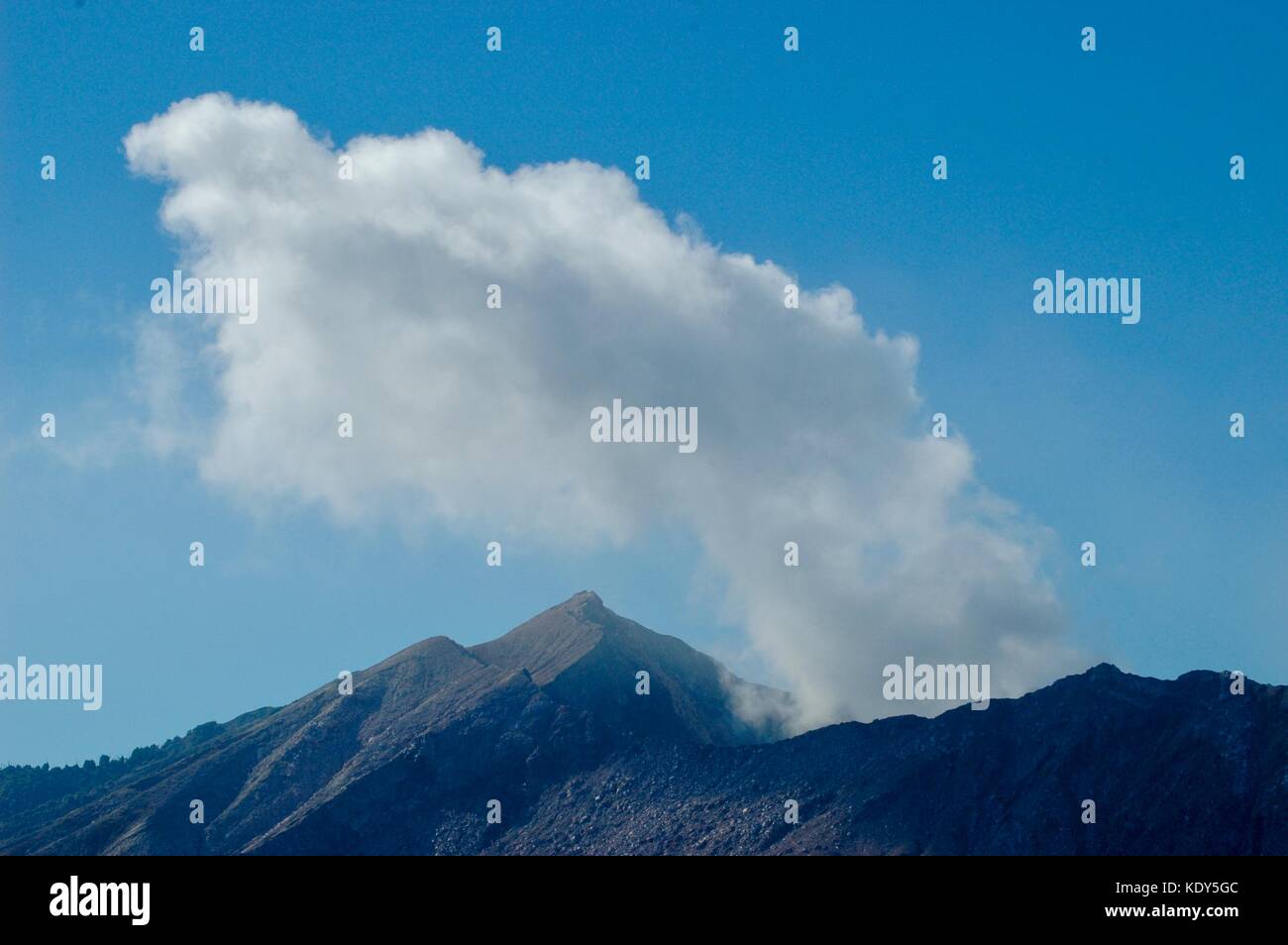 Smoke is rising form an active volcano. The mouth of the volcano is ...