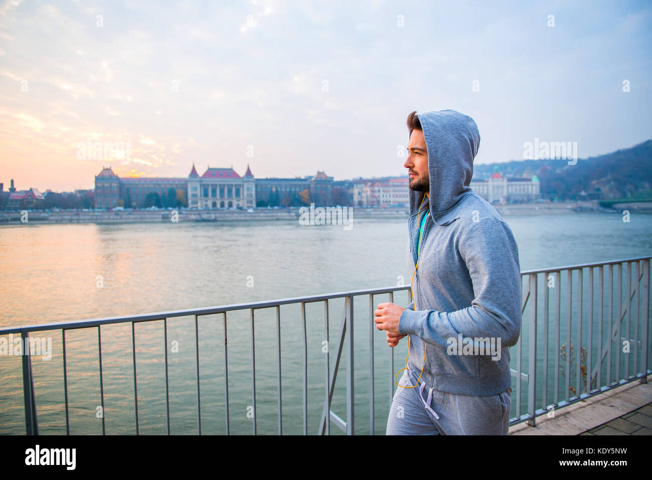 A handsome young man running at the riverside in the sunset Stock Photo ...