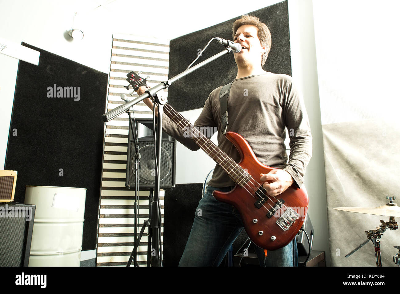A Rock musician playing passionately bass in the rehearsal Studio Stock ...