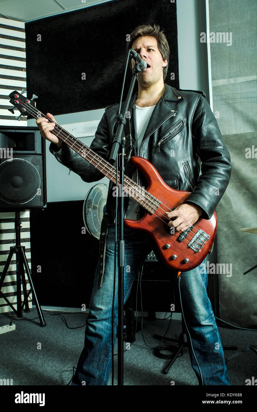 A Rock musician playing passionately bass in the rehearsal Studio Stock ...