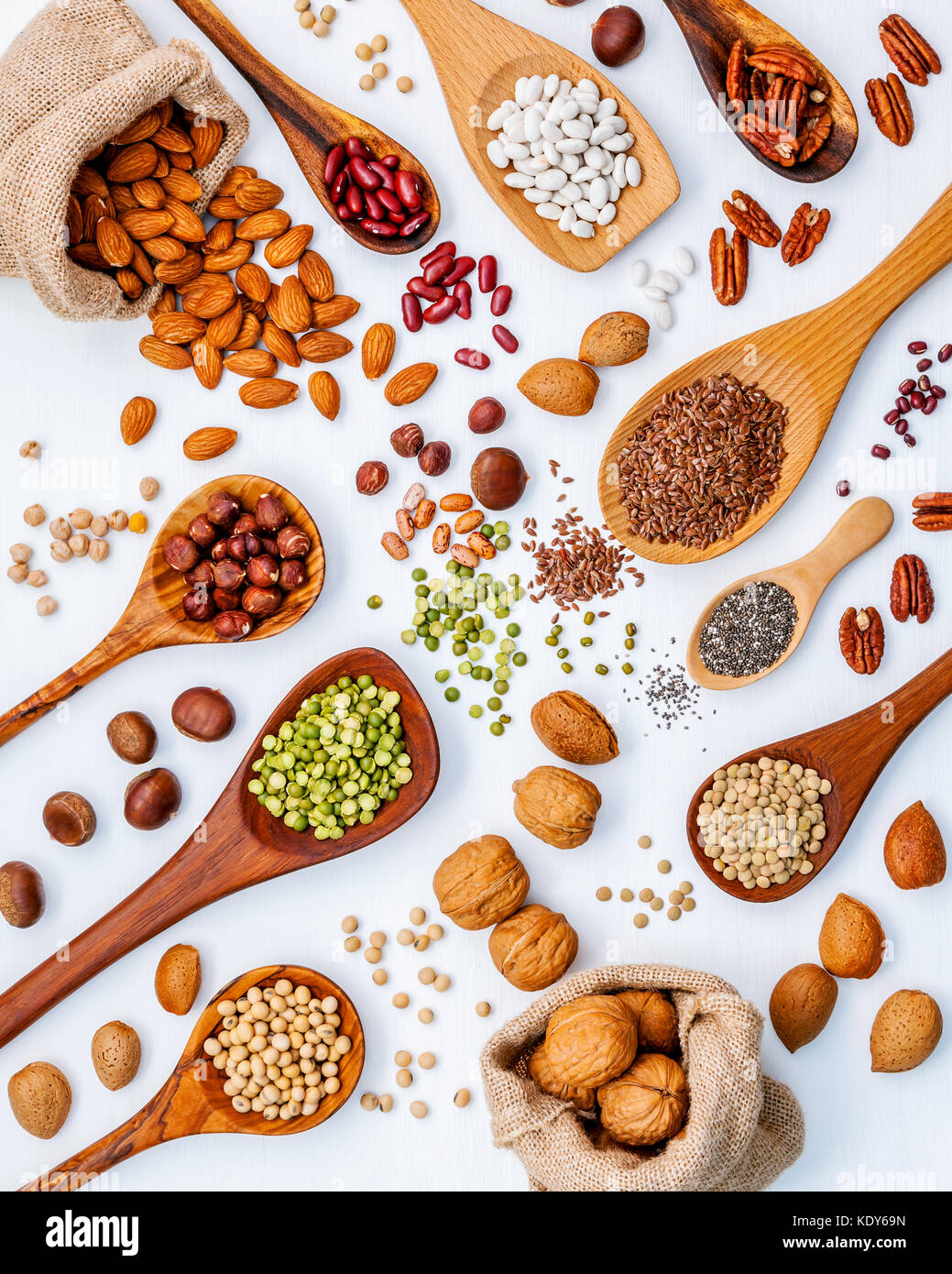 Various legumes and different kinds of nuts in spoons. Walnuts kernels ...