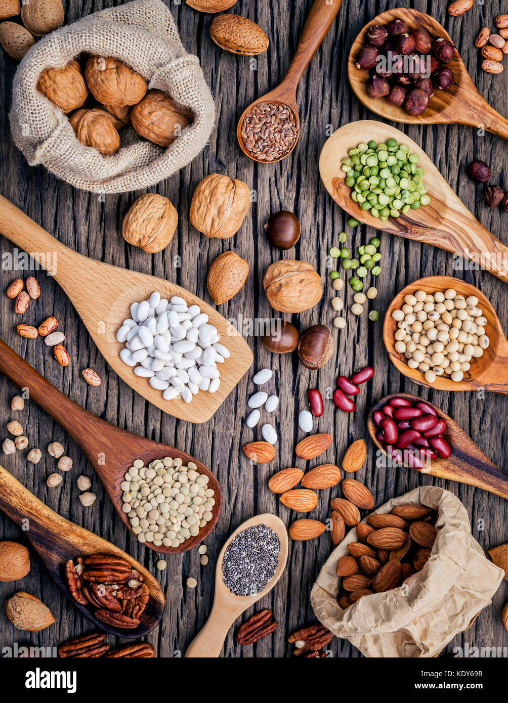 Various legumes and different kinds of nutshells in spoons. Walnuts ...
