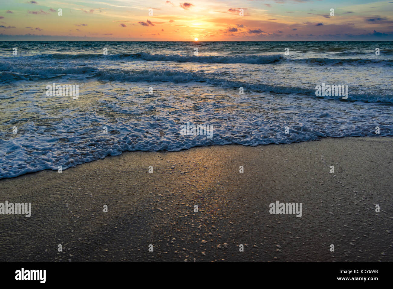 warm sun rising on the horizon seen from the shore Stock Photo - Alamy