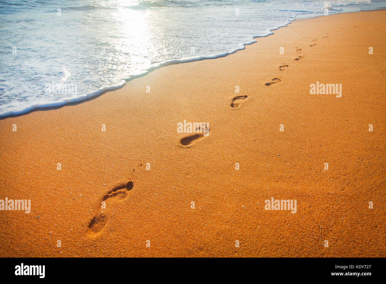 beach, wave and footprints at sunset time Stock Photo - Alamy