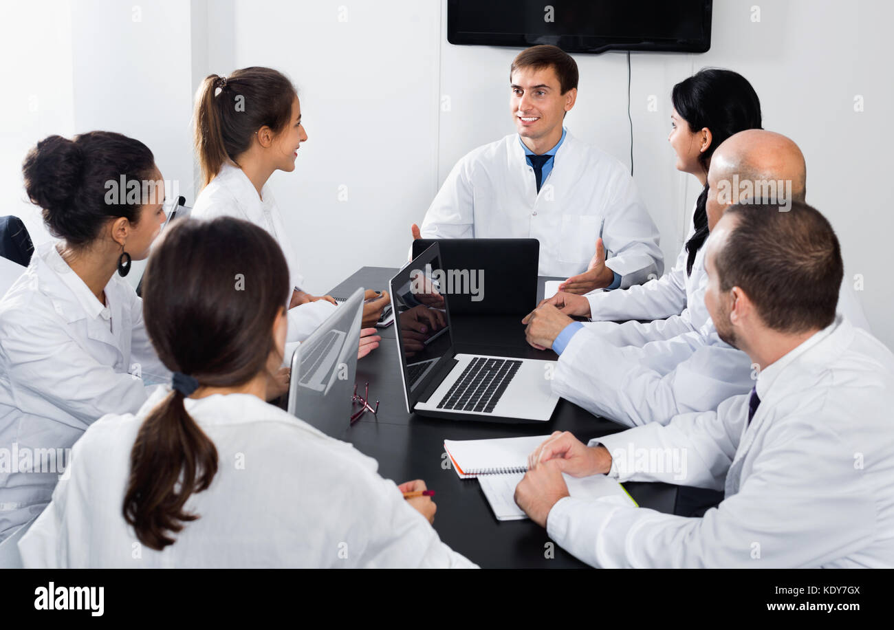 Diligent friendly scientist presenting report during working meeting in ...
