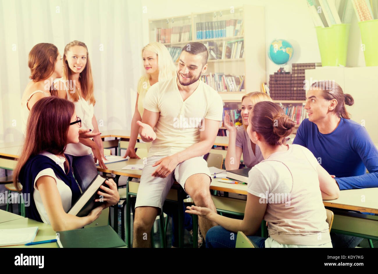 Friendly international students chatting while sitting in the room ...