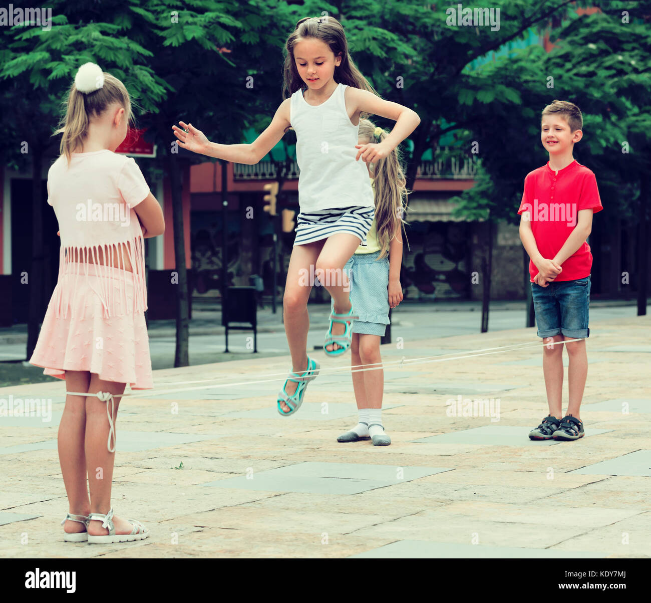 cheerful boy and girls in elementary school age jumping over chinese ...