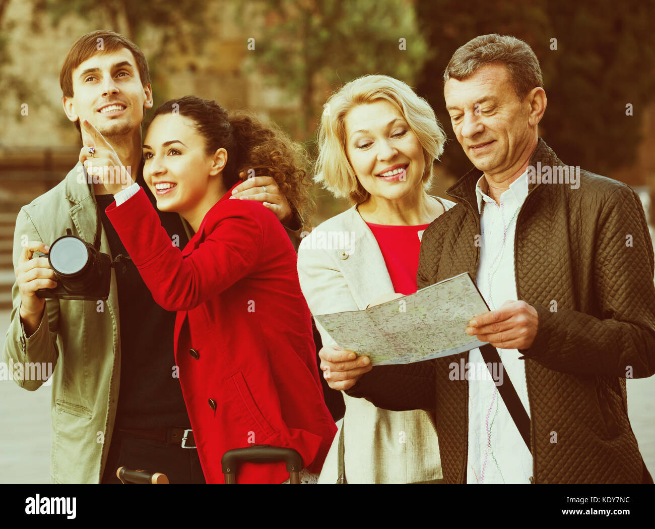 Family of four reading city map and sightseeing outdoors. Focus on ...